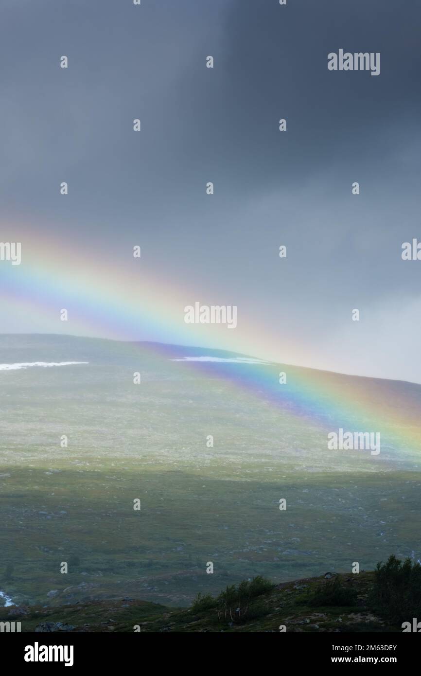 Amazing rainbow in cloudy sky over the tundra landscape on the Arctic ...