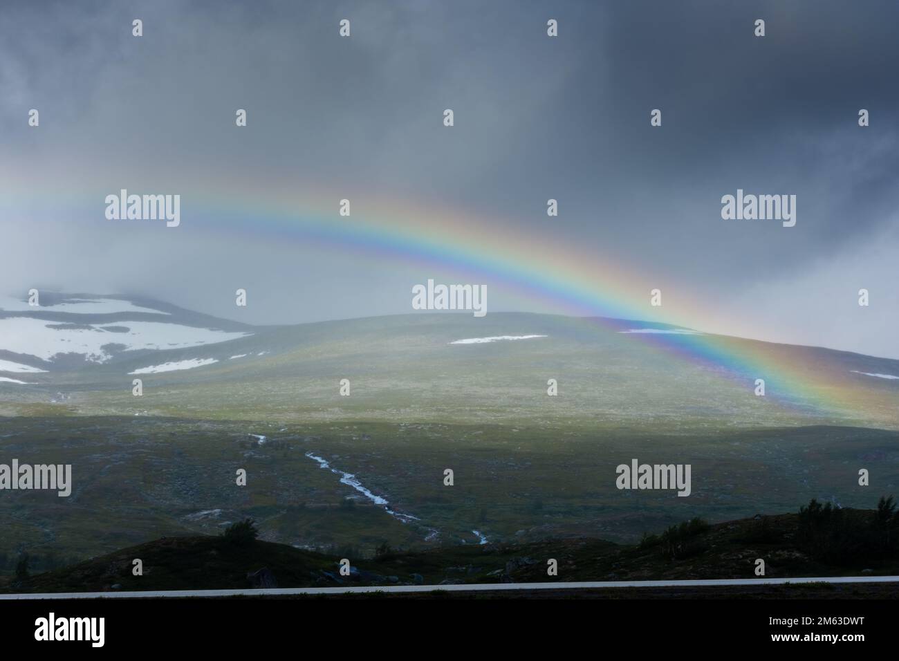 Amazing rainbow in cloudy sky over the tundra landscape on the Arctic ...