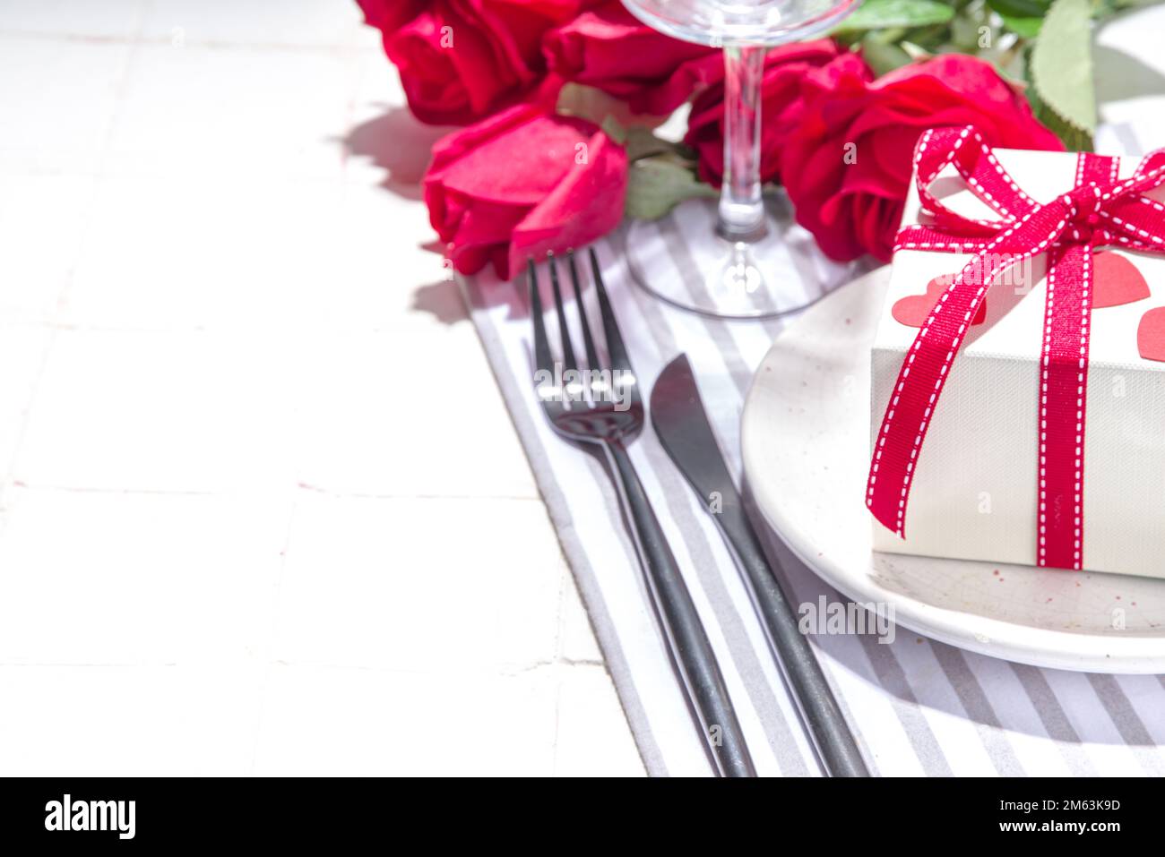 Valentine day table setting with plate, gift box with festive red ...