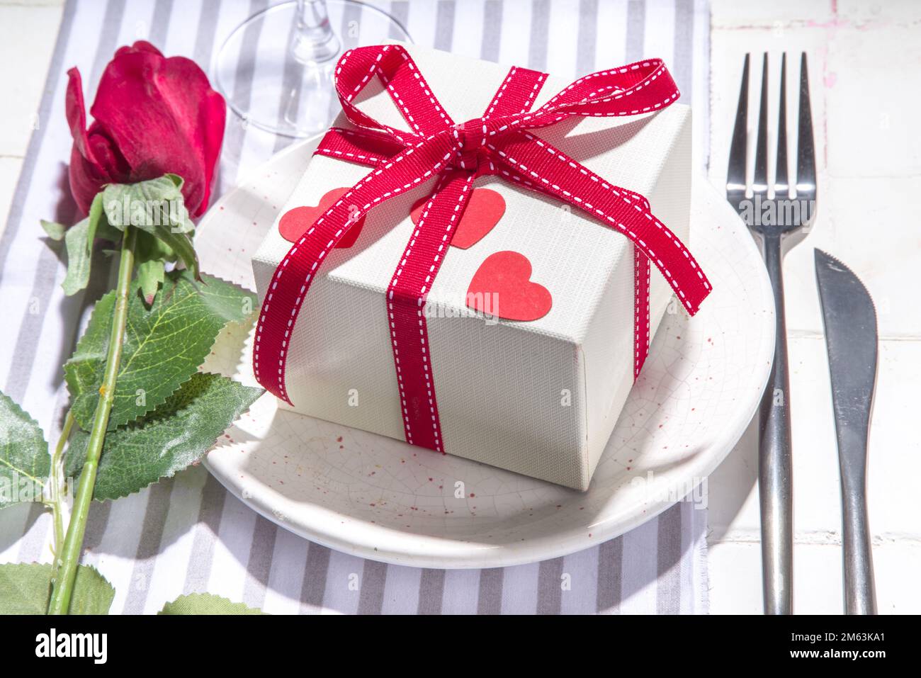 Valentine day table setting with plate, gift box with festive red ...