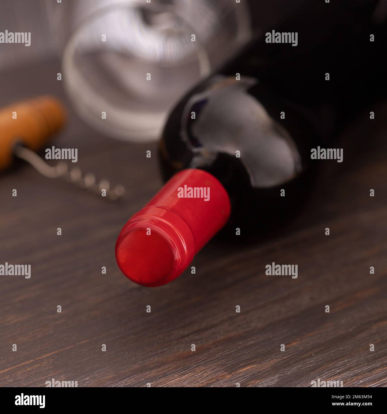 Red wine bottle with wine glass and corkscrew on wooden table. Wine ...
