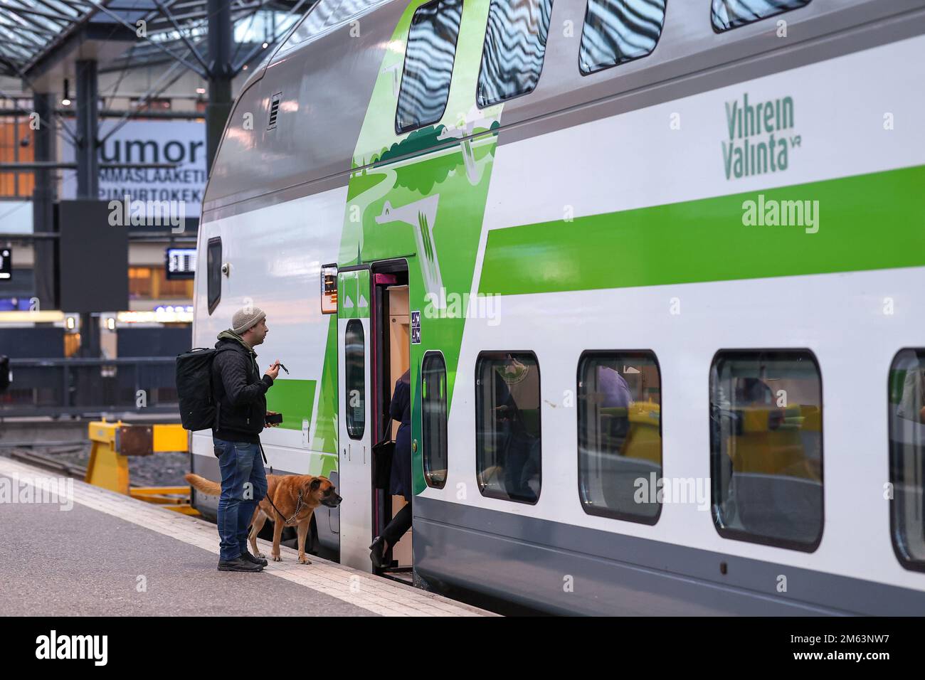 A man with dog enter the train carriage on the railway platform of ...