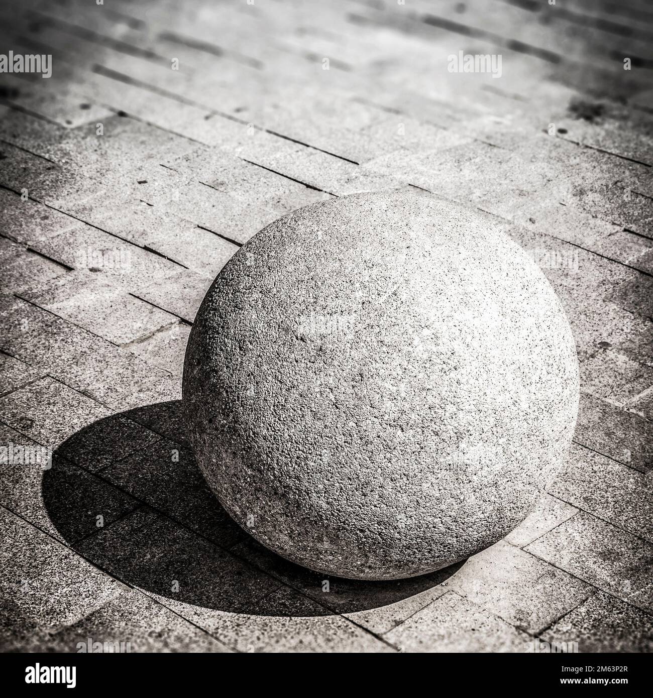 A large stone ball lies on a stone pavement Stock Photo - Alamy
