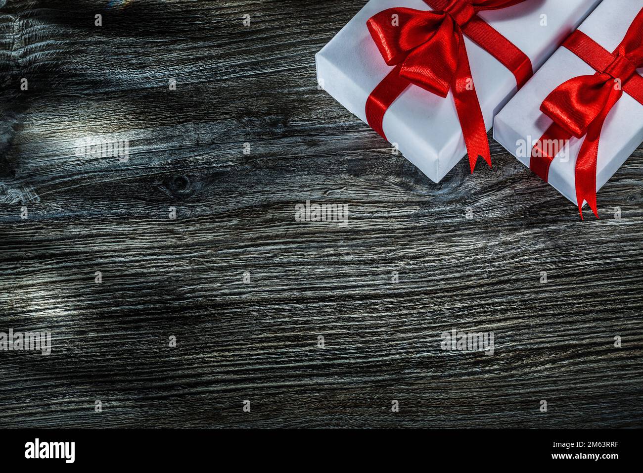 White present box with red knot on wooden board Stock Photo - Alamy
