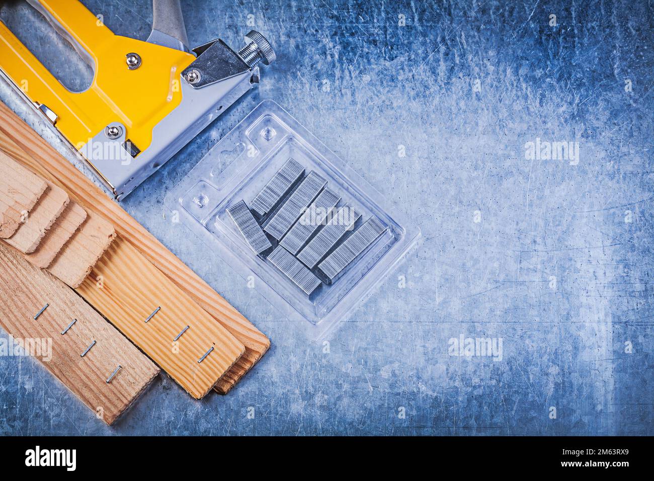 Yellow construction stapler metal staples wooden building board on ...