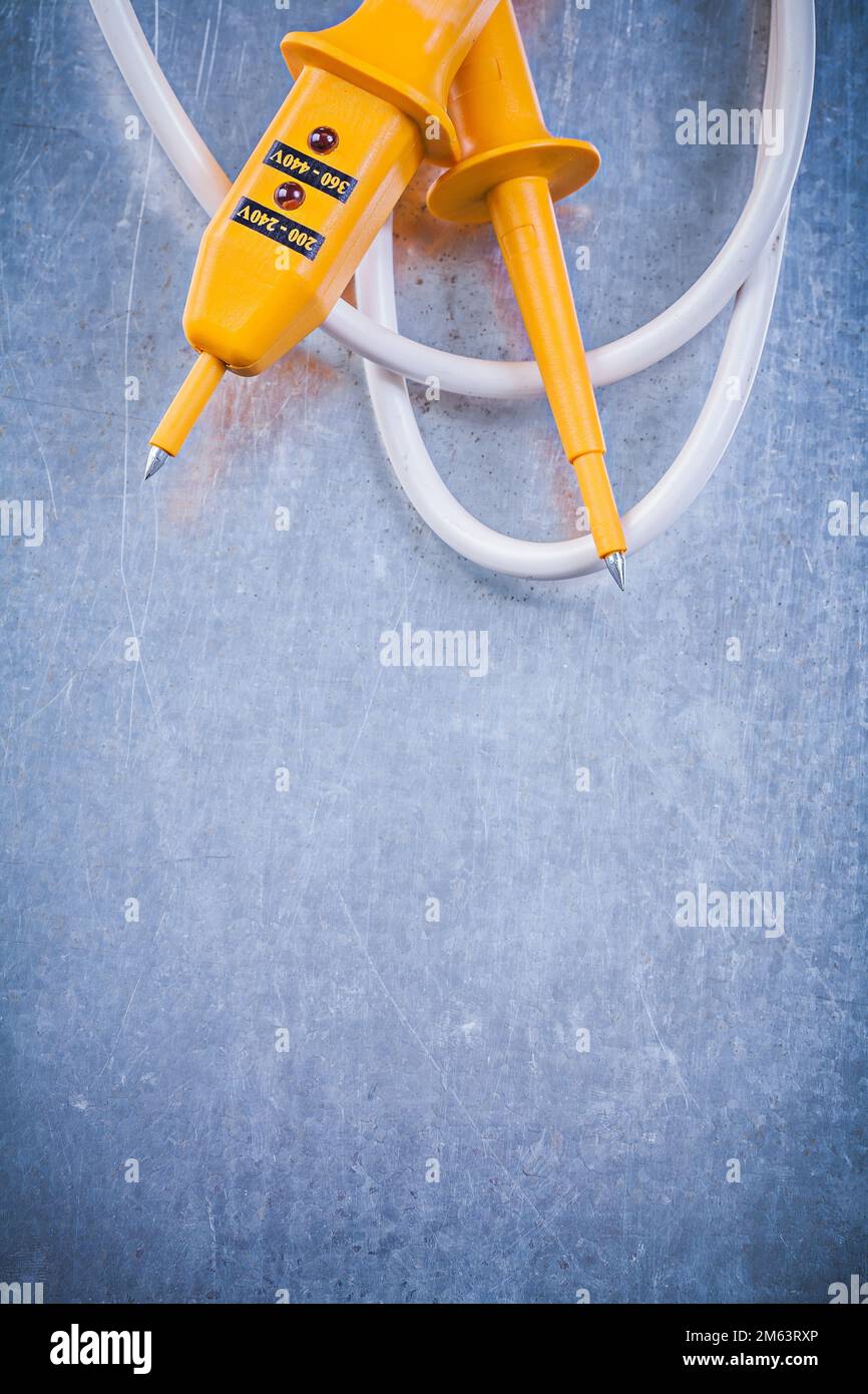 Yellow electrical tester on metallic background electricity concept ...
