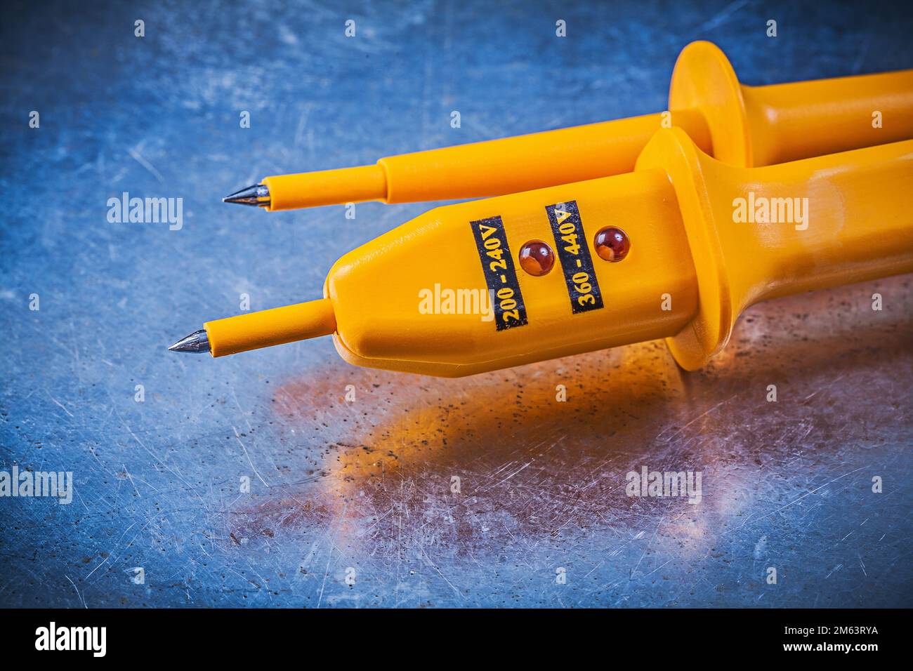 Yellow electrical tester on metallic background close up view ...