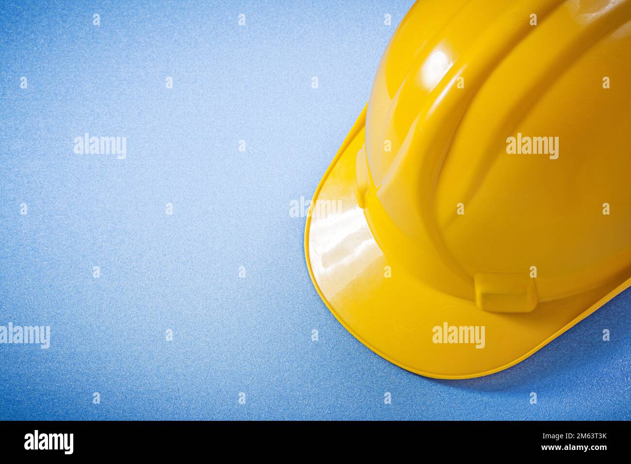 Yellow safety helmet on blue surface construction concept Stock Photo ...