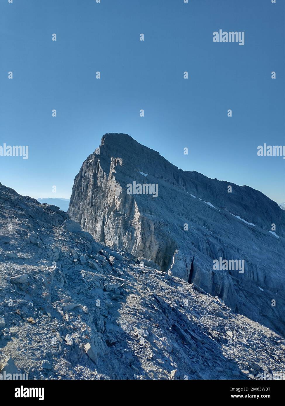 A vertical shot of mount Rundle Traverse under a blue sky in Alberta ...