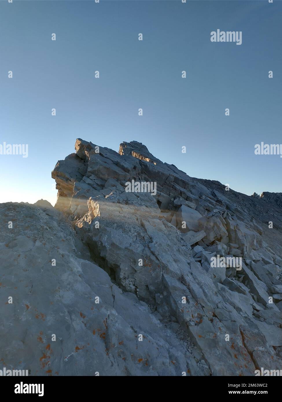 A vertical shot of mount Rundle Traverse under a blue sky in Alberta ...