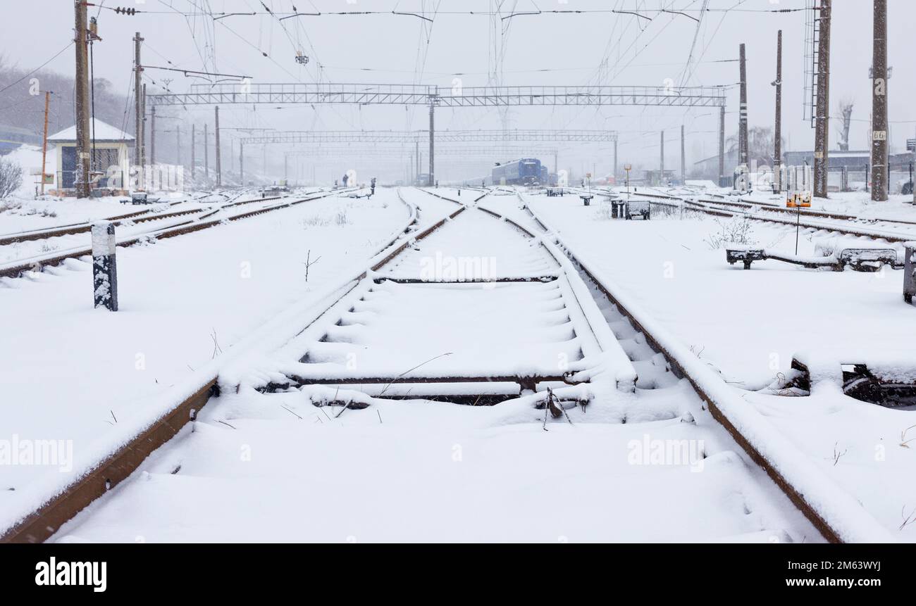 Multiple train tracks during snowfall quickly covered with fluffy white ...