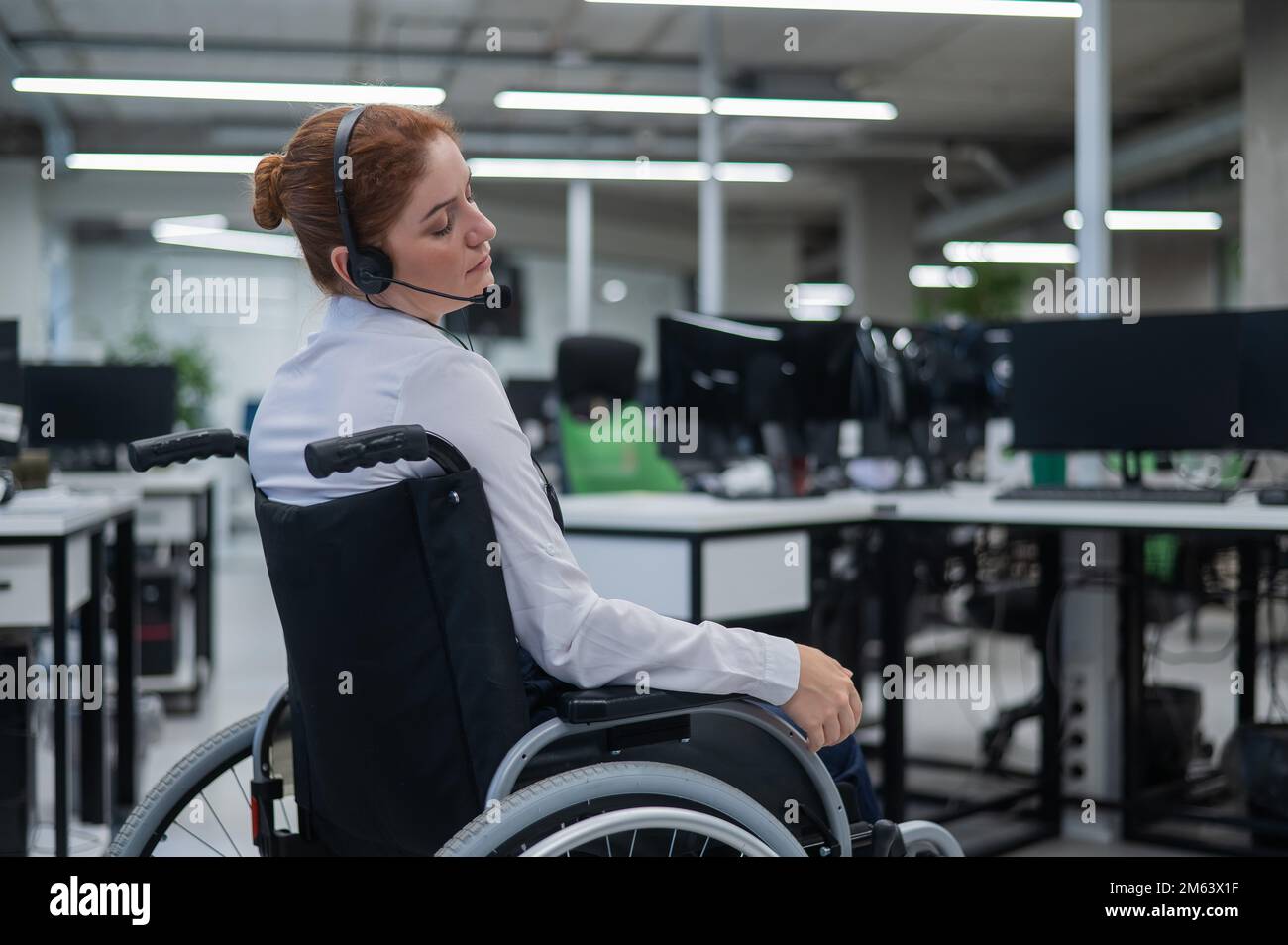 Caucasian woman on a wheelchair sleeping at work. Female call center ...