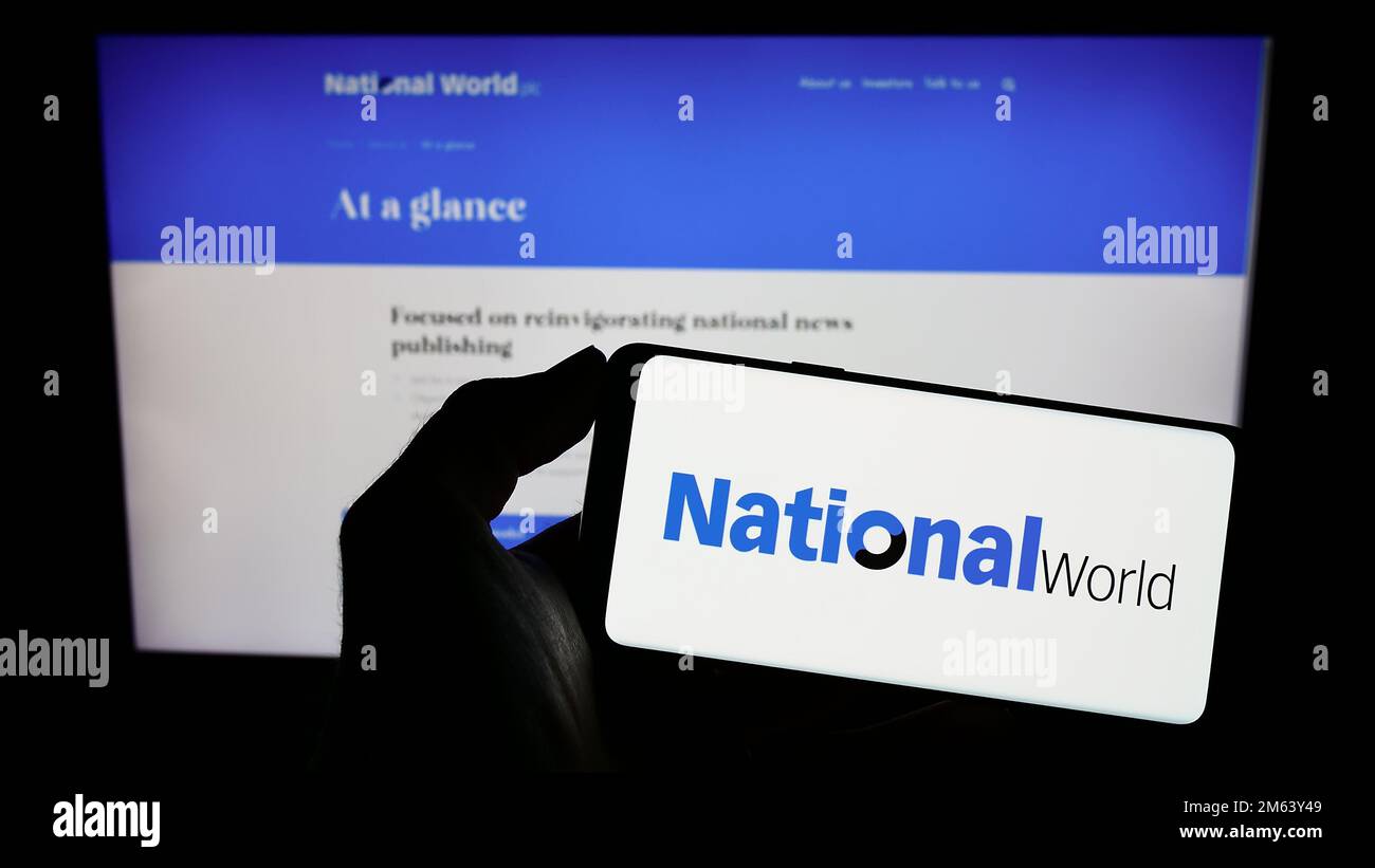 Person holding cellphone with logo of British media company National ...