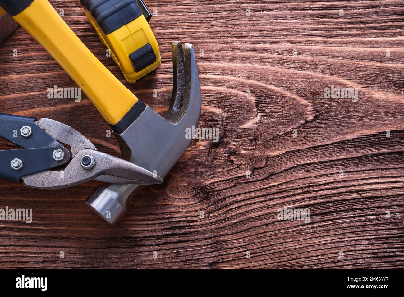 Claw hammer nippers and tape-measure on wood board construction concept ...