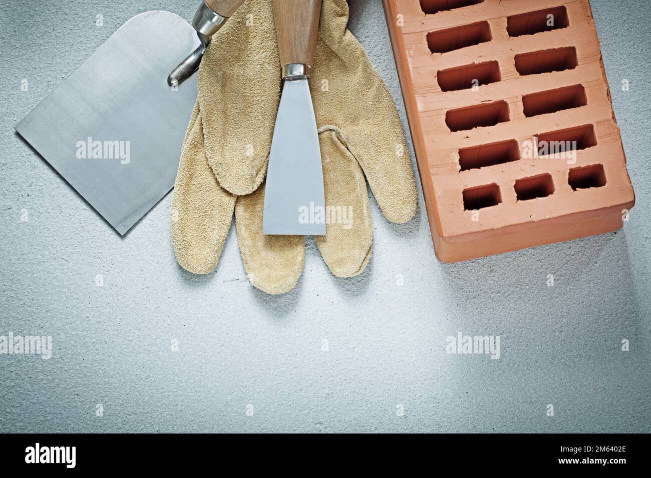 Construction brick protective gloves paint scrapers on concrete surface ...