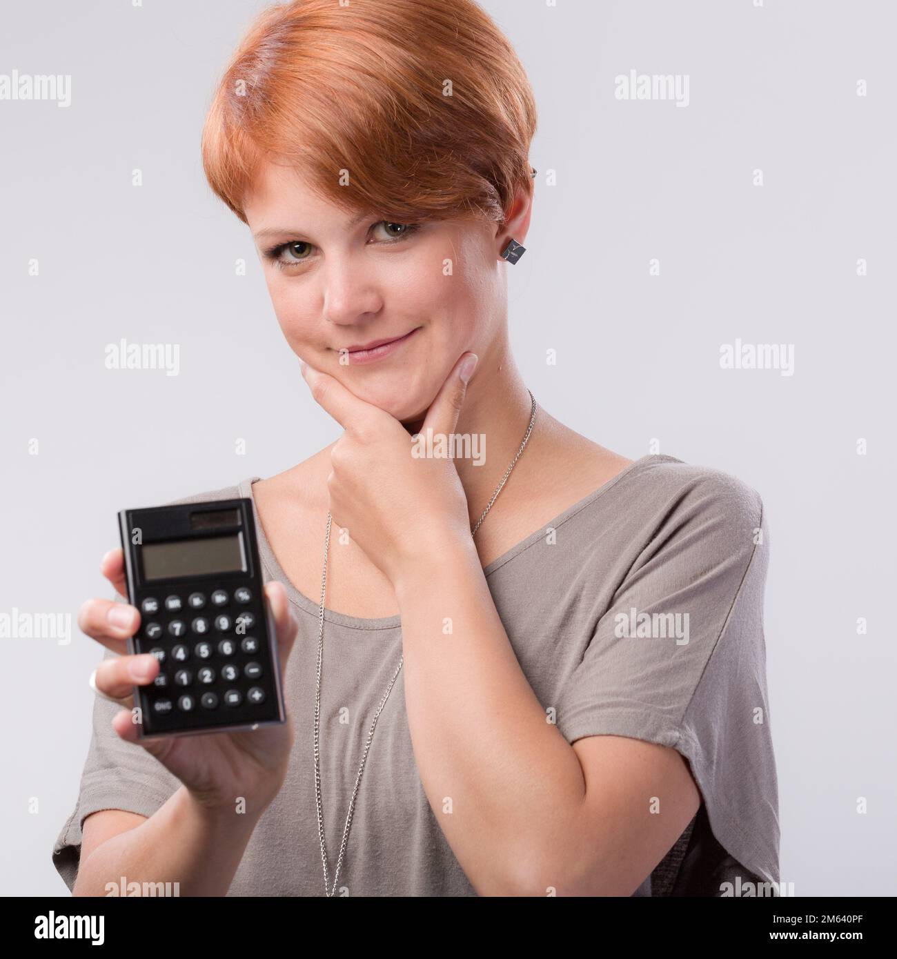 Young thinking woman is using a calculator Stock Photo - Alamy