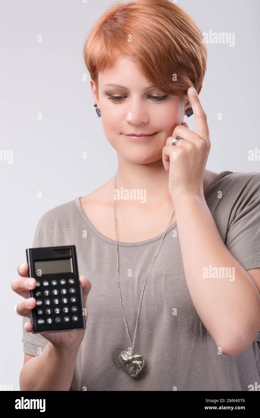Young thinking woman is using a calculator Stock Photo - Alamy