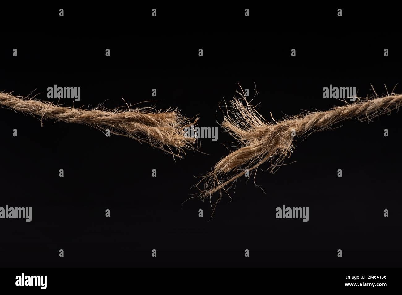 Breaking rope isolated on black background Stock Photo - Alamy