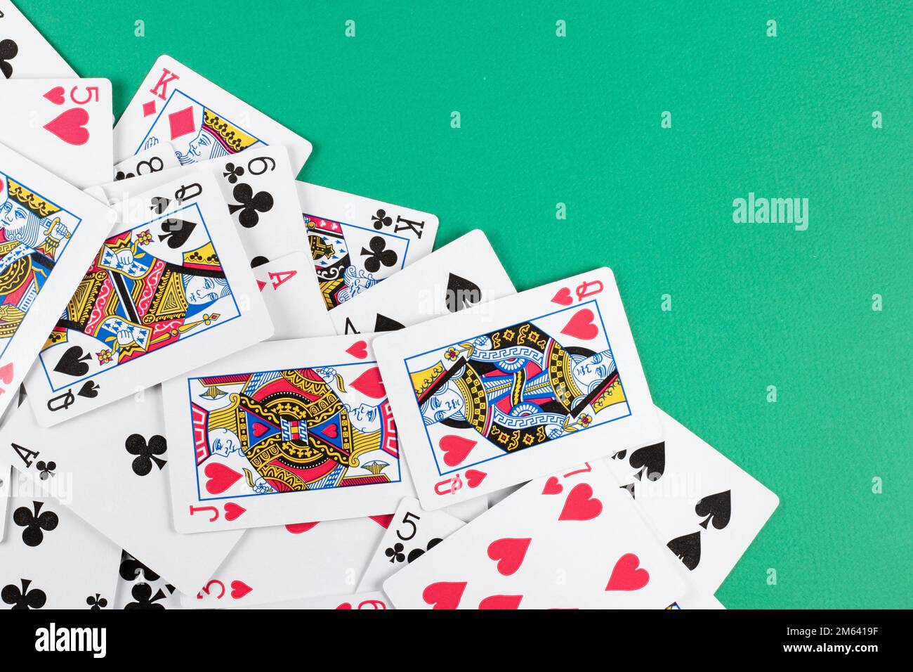 Playing cards on green background Stock Photo - Alamy