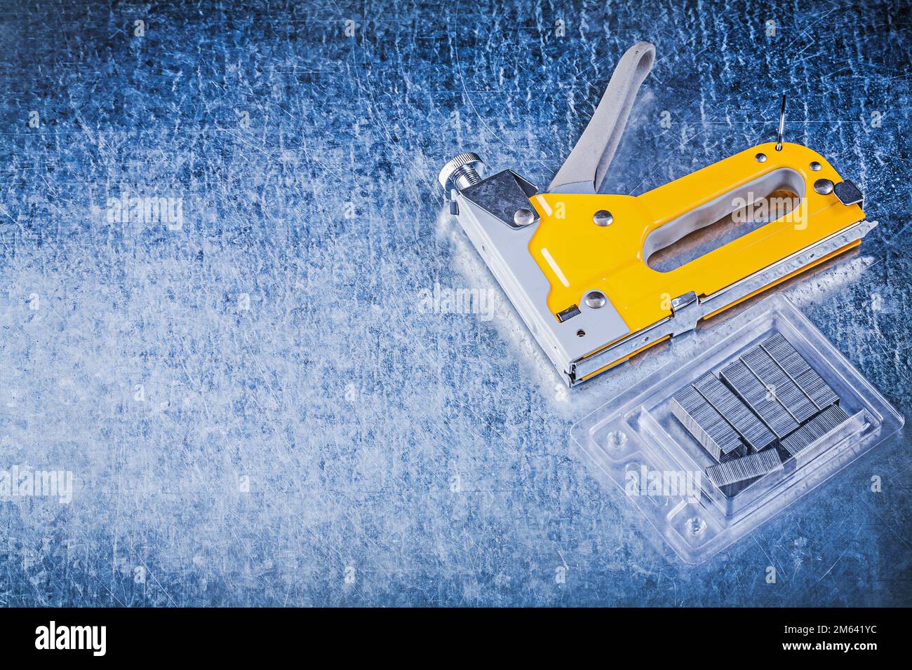 Construction stapler chrome staples on scratched metallic background ...
