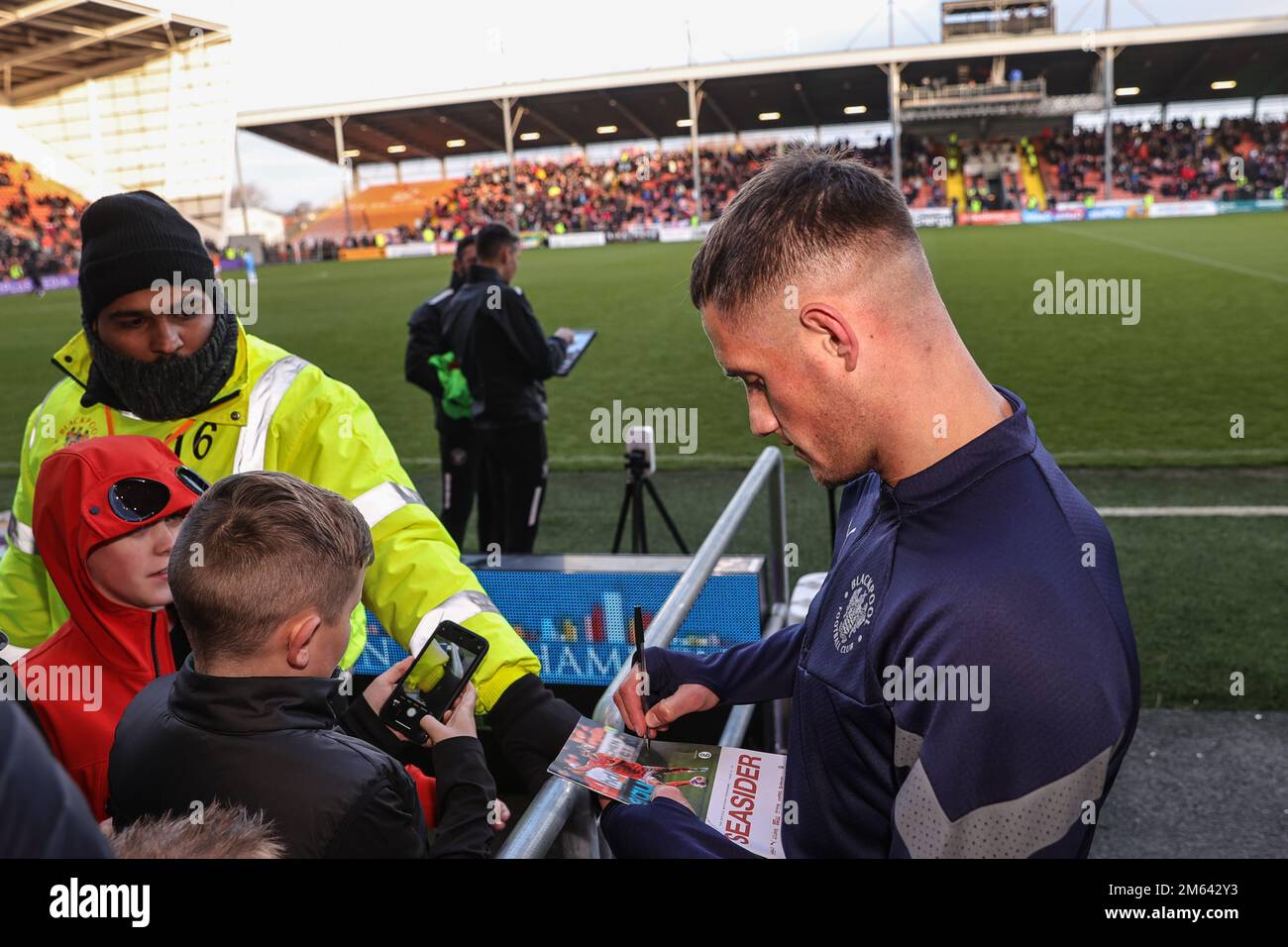 Jerry Yates #9 of Blackpool signs a fans program during the Sky Bet ...