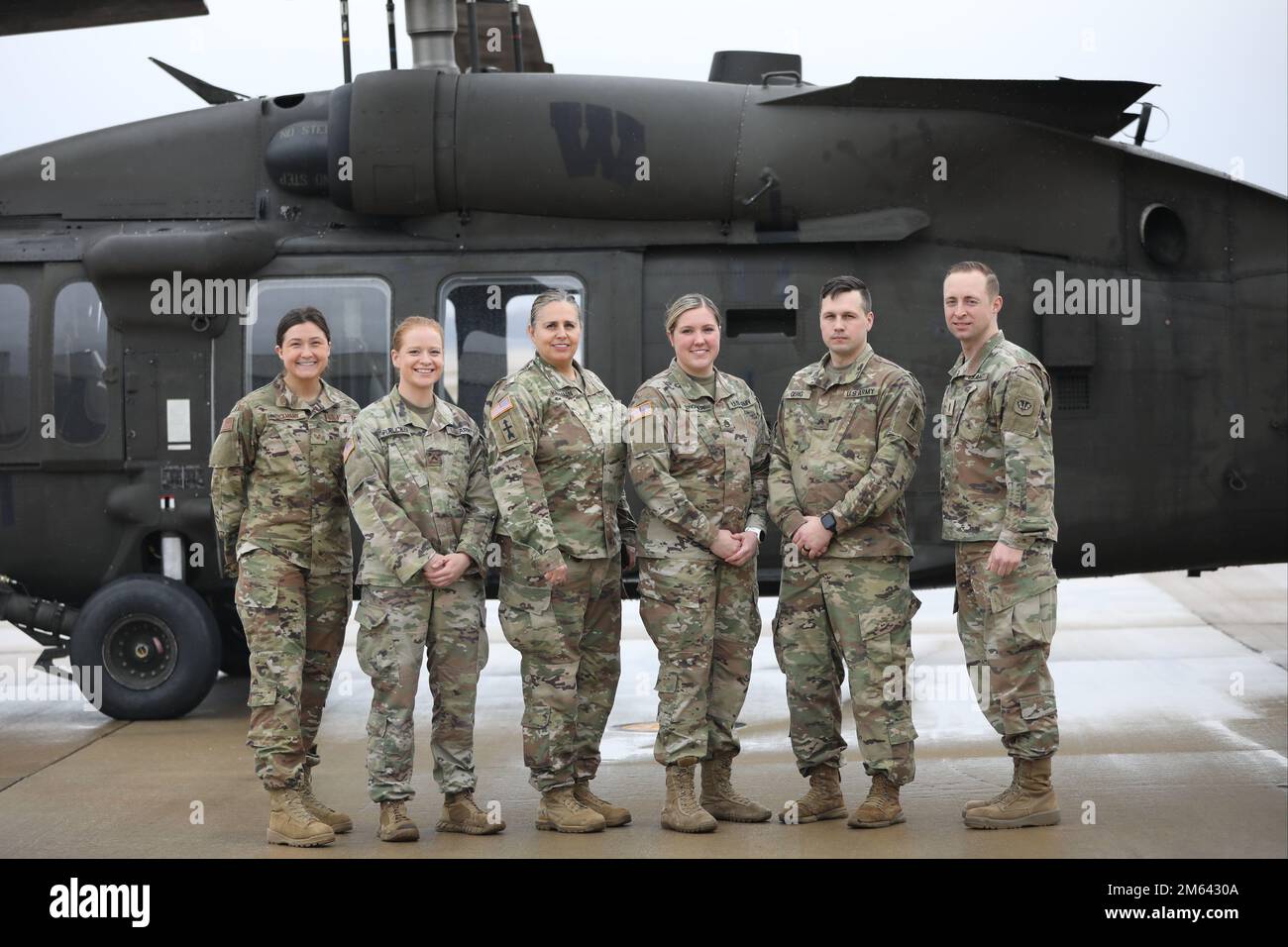 Sgt. James Gerig poses with close peers in front of a UH-60 Blackhawk ...