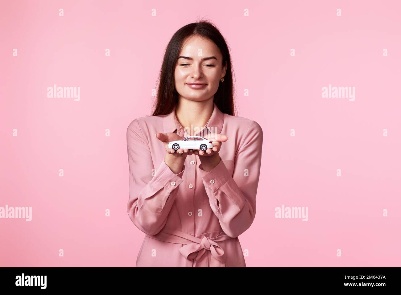 beautiful woman in dress holding little white car Stock Photo - Alamy
