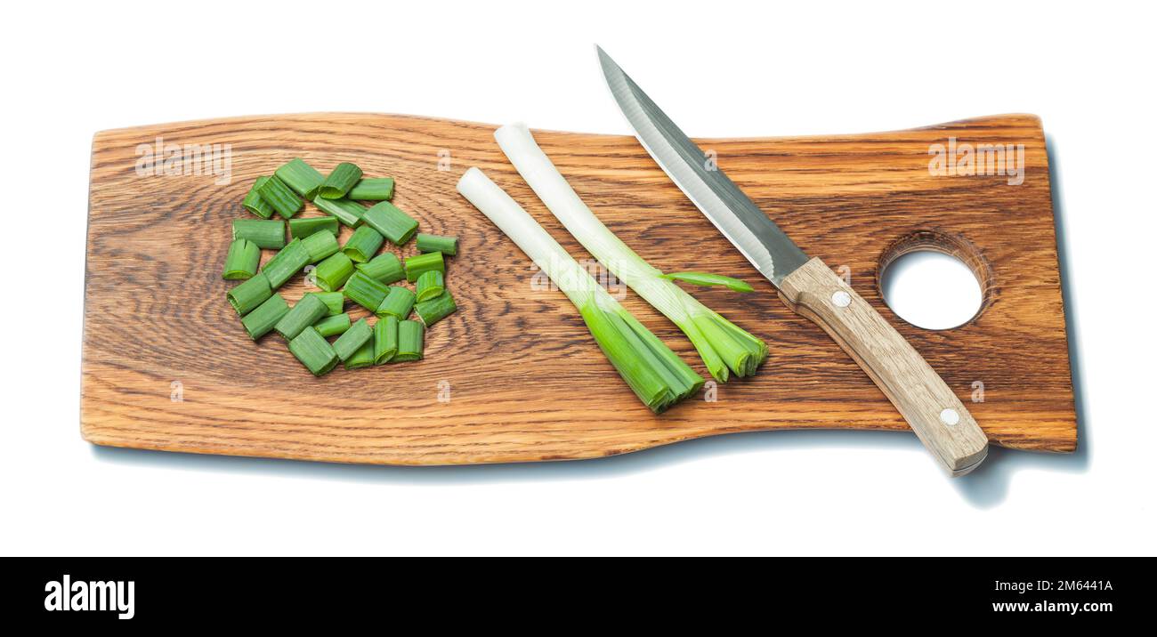 kitchen knife and chopped spring green onion stems on wooden chopping ...
