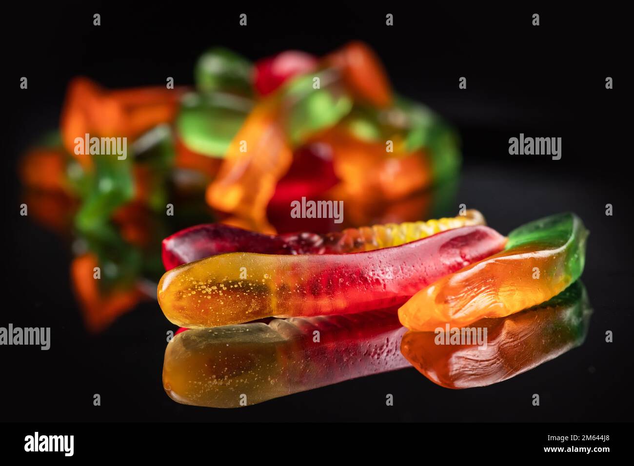 Juicy colorful jelly worms sweets. Gummy candies. Snakes. On black ...
