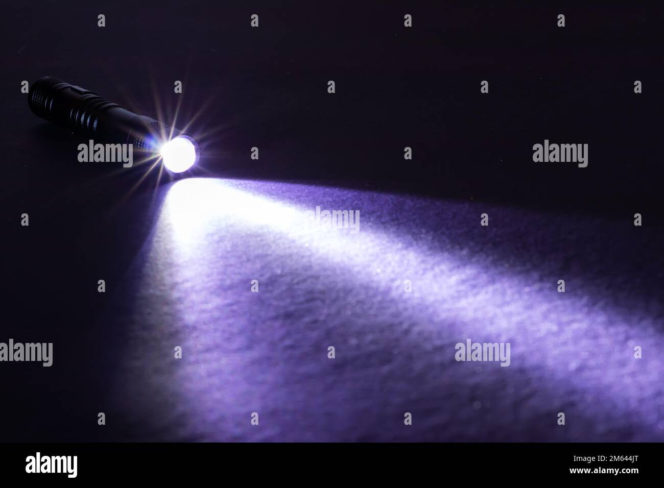 Flashlight and a beam of light in darkness. A modern led lamp with ...