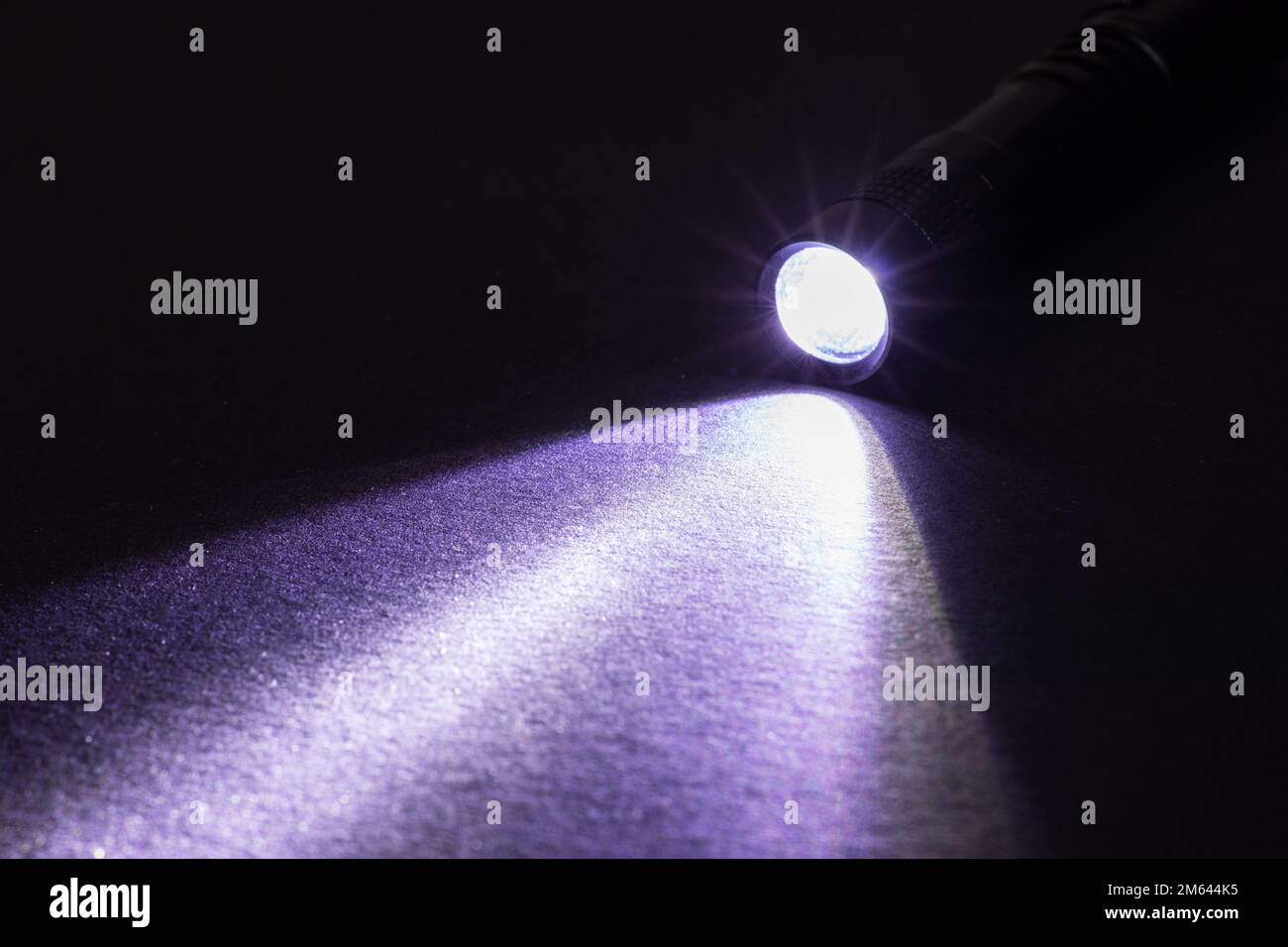 Flashlight and a beam of light in darkness. A modern led lamp with ...