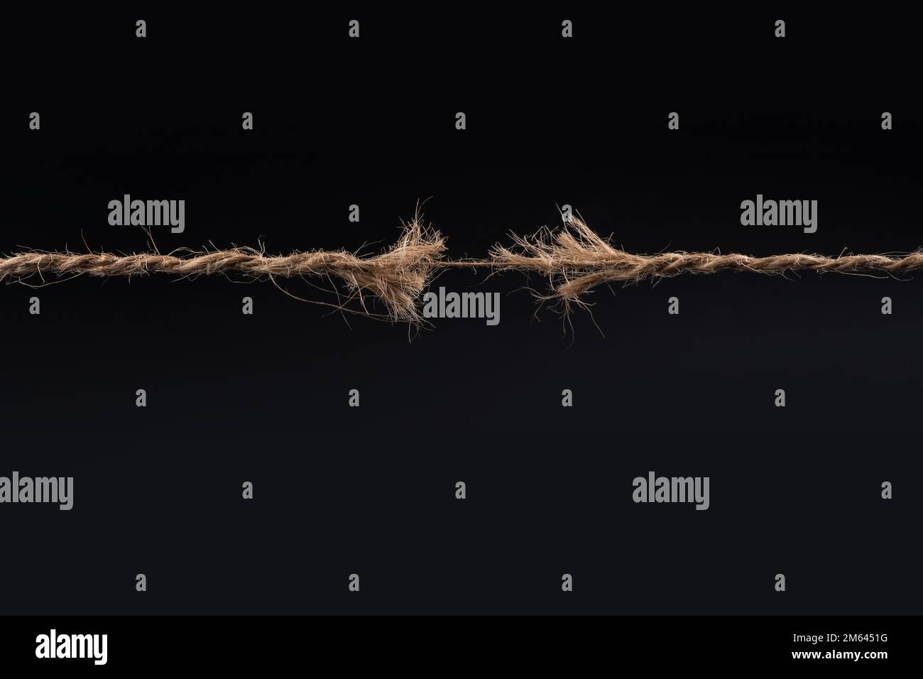 Frayed rope ready to break isolated on black background Stock Photo - Alamy