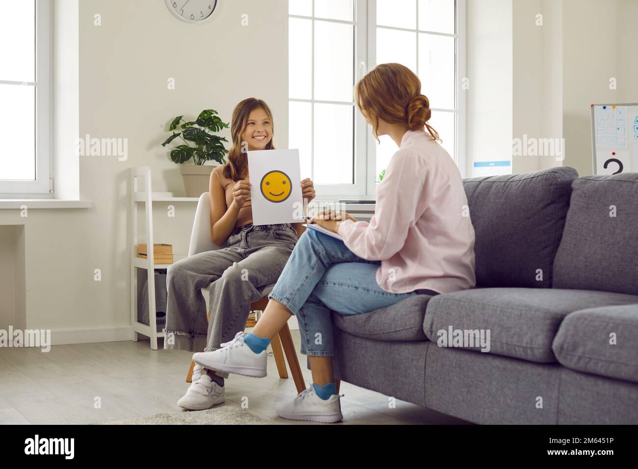 Happy teen patient talking to psychologist about positive emotions ...