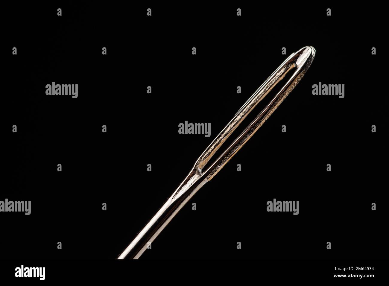 Macro of a needle, needle's eye with isolated on black background focus ...