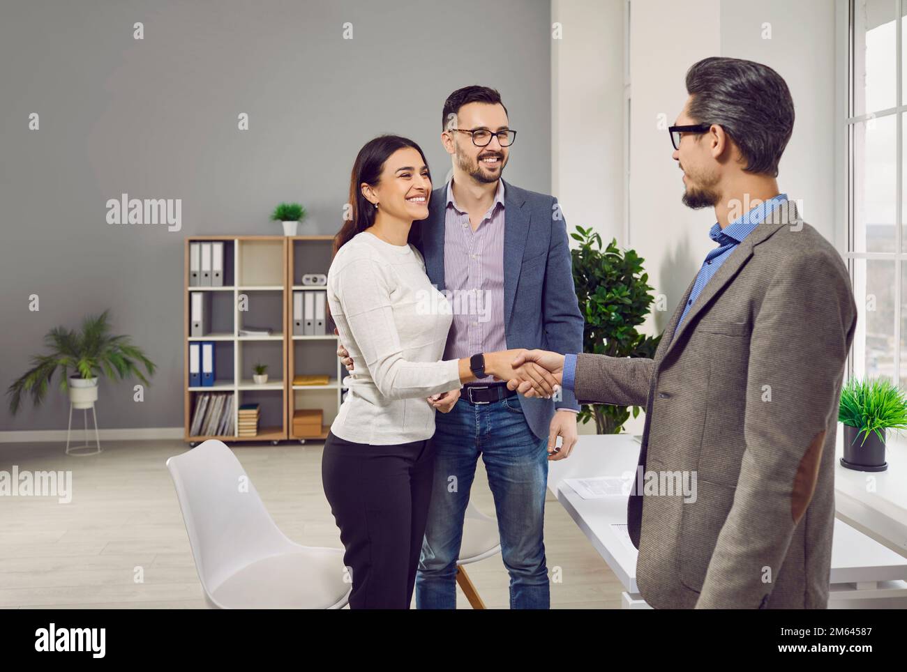 Happy young couple meeting with bank manager, lawyer, real estate agent ...
