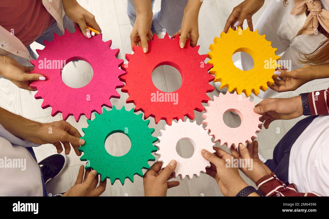 Team of people holding and connecting gears showing concept of teamwork ...