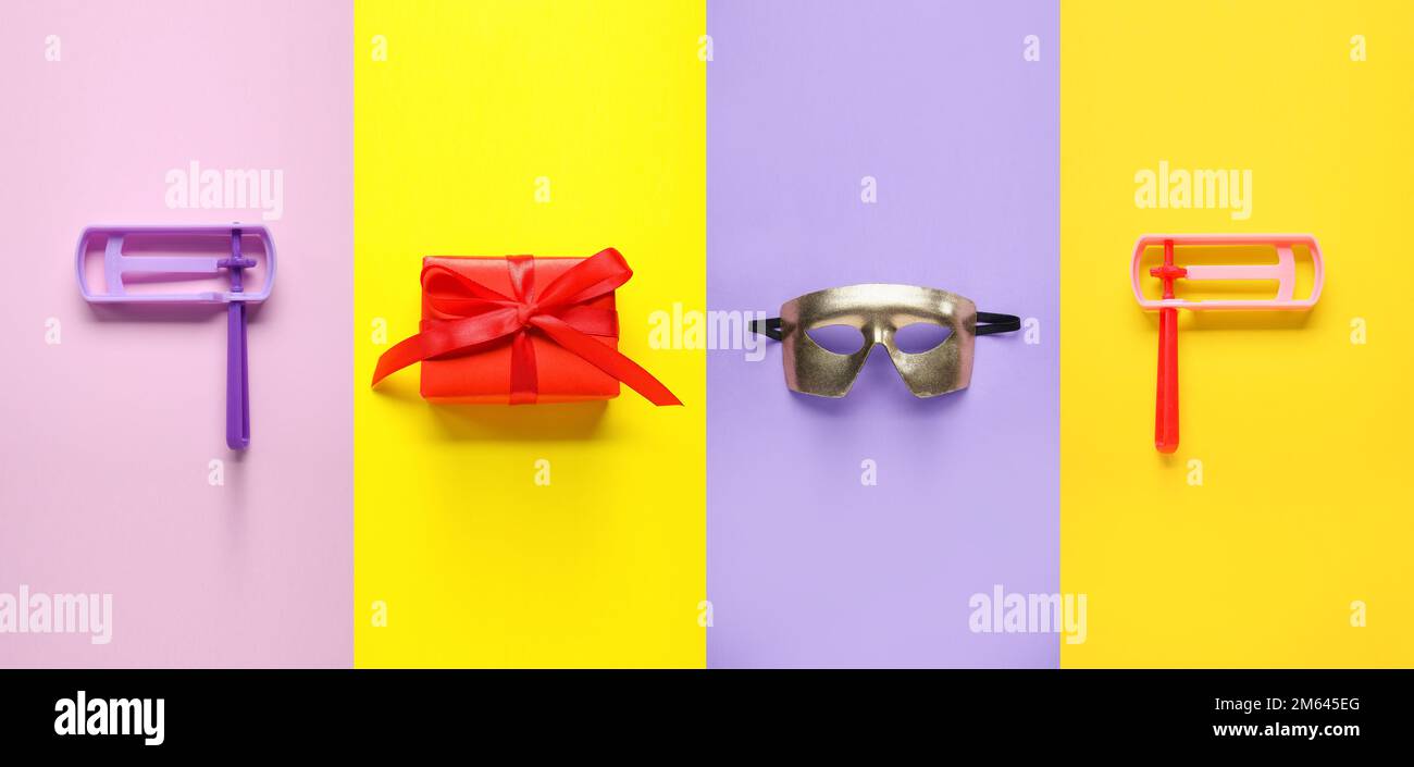 Collage of traditional symbols of Purim and gift on color background ...