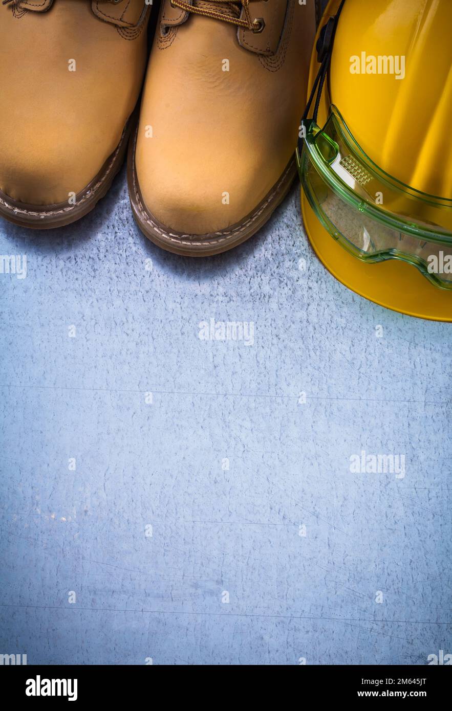 Pair of safety shoes building helmet and transparent plastic glasses on ...