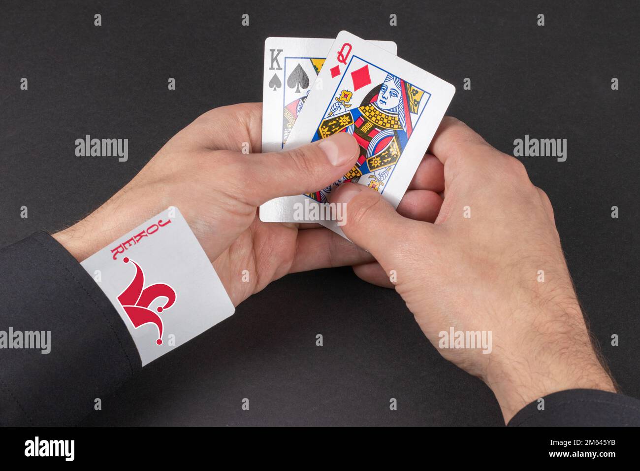 Concept - joker card in the sleeve. A man holding cards in his hands on ...