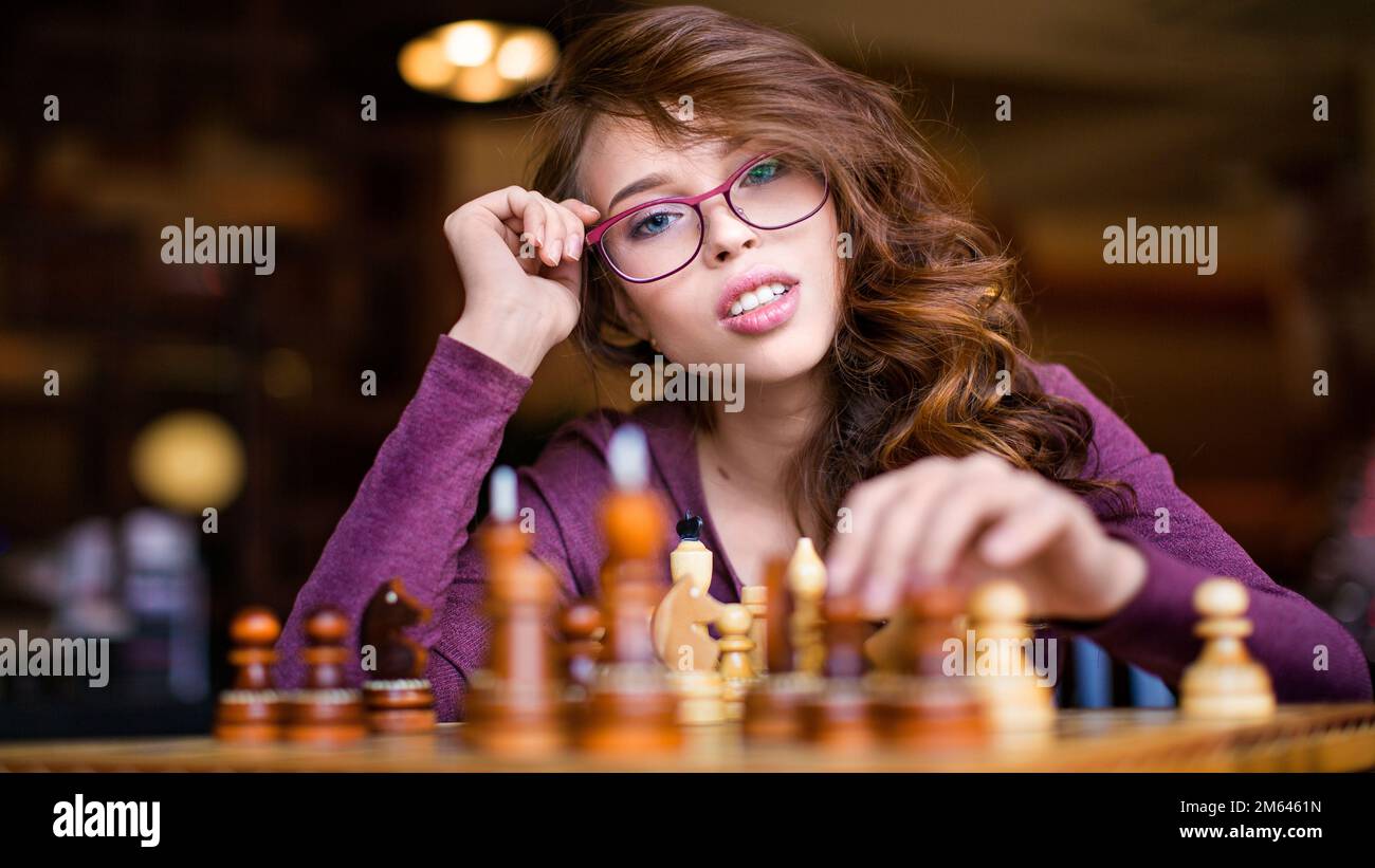Woman playing chess indoor and thinking position, find winning move ...