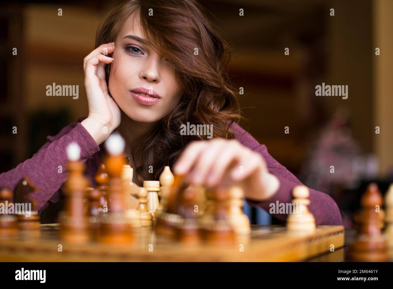 Woman playing chess indoor and thinking position, find winning move ...
