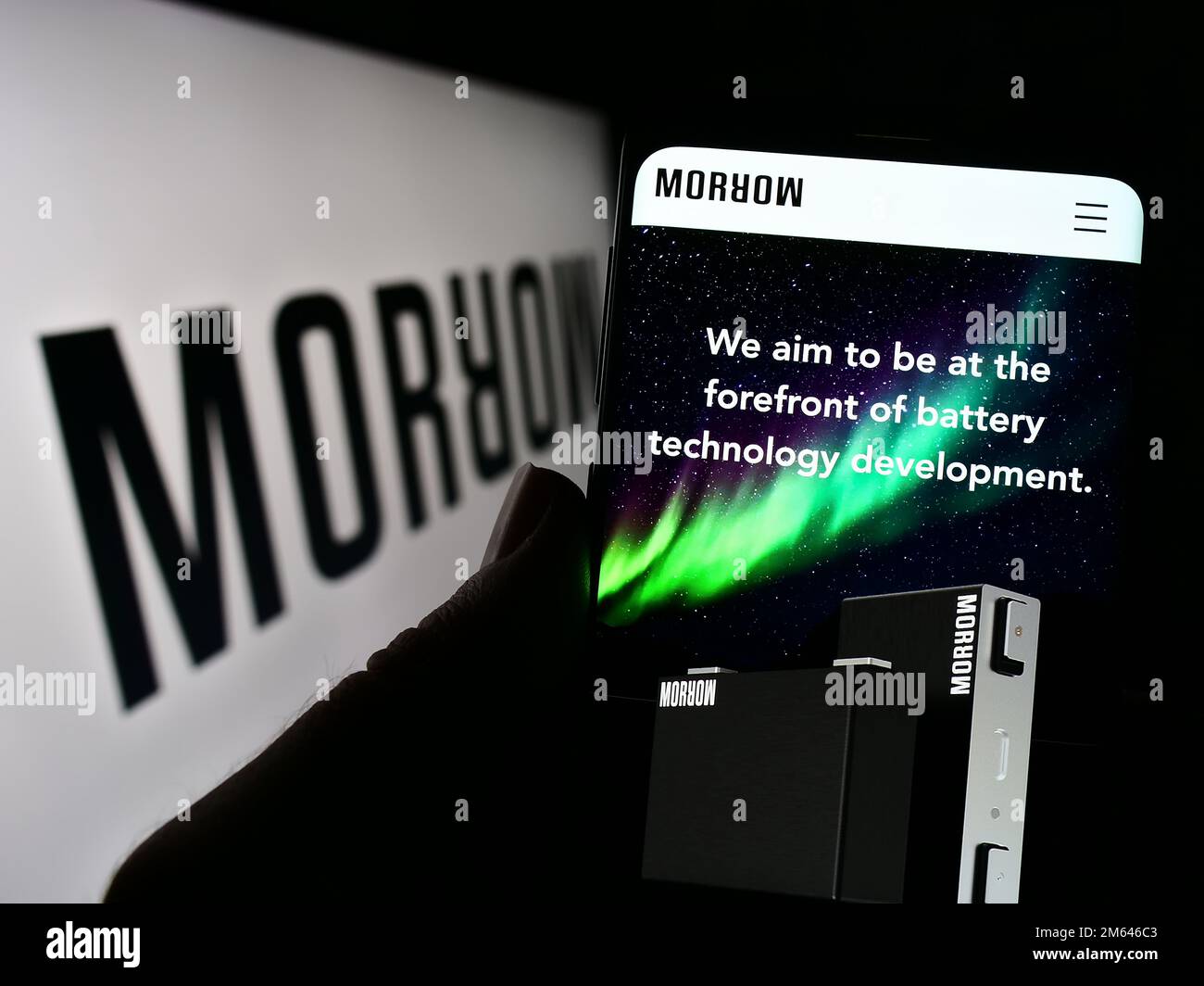 Person holding cellphone with website of Norwegian battery company ...