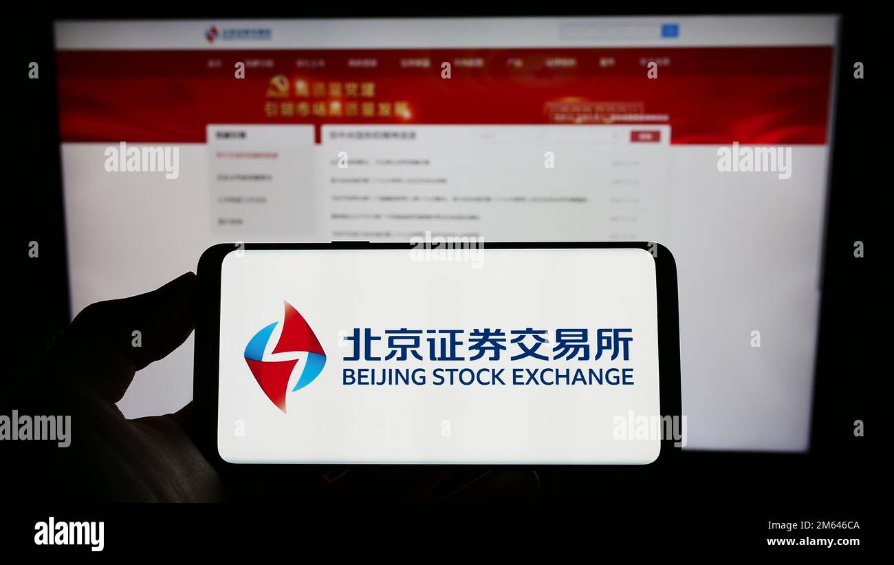 Person holding smartphone with logo of Chinese company Beijing Stock ...