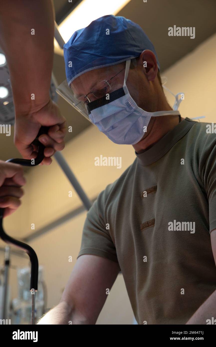 A German Surgical Teammember, holds a femur replica during a ...