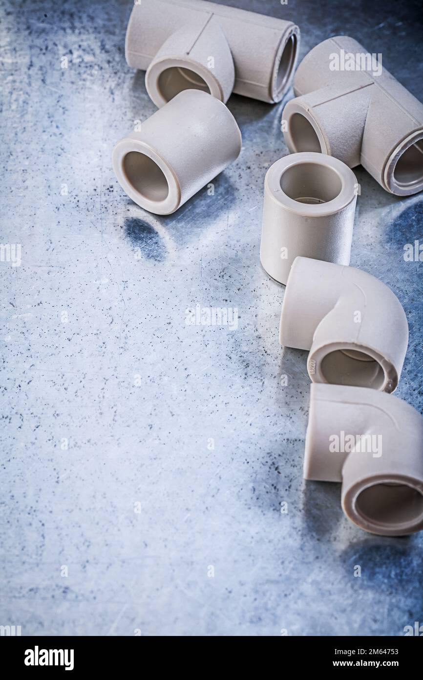 Set of plastic pipe connectors on metallic surface construction concept ...