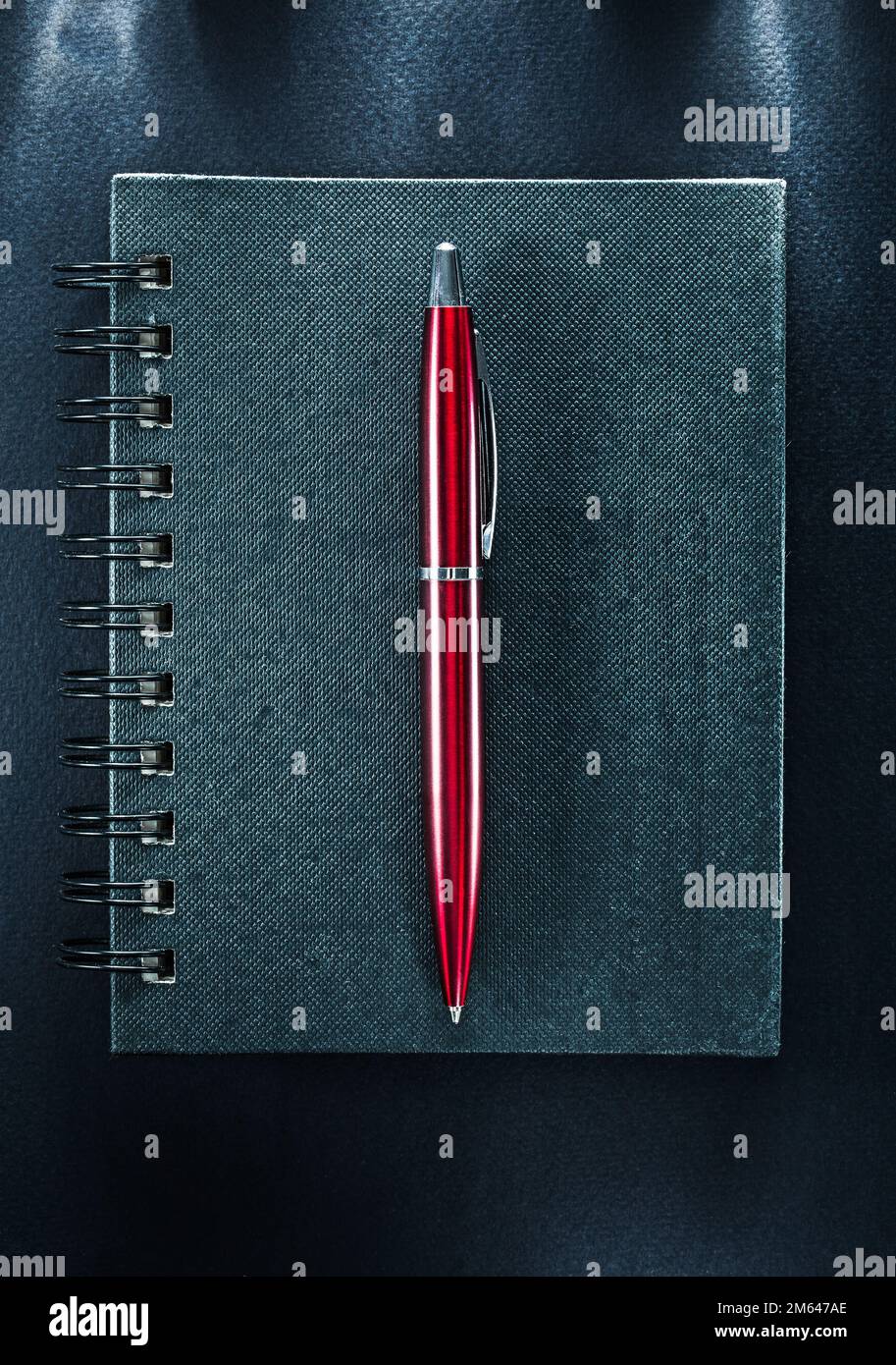 Spiral notebook pen on black background Stock Photo - Alamy