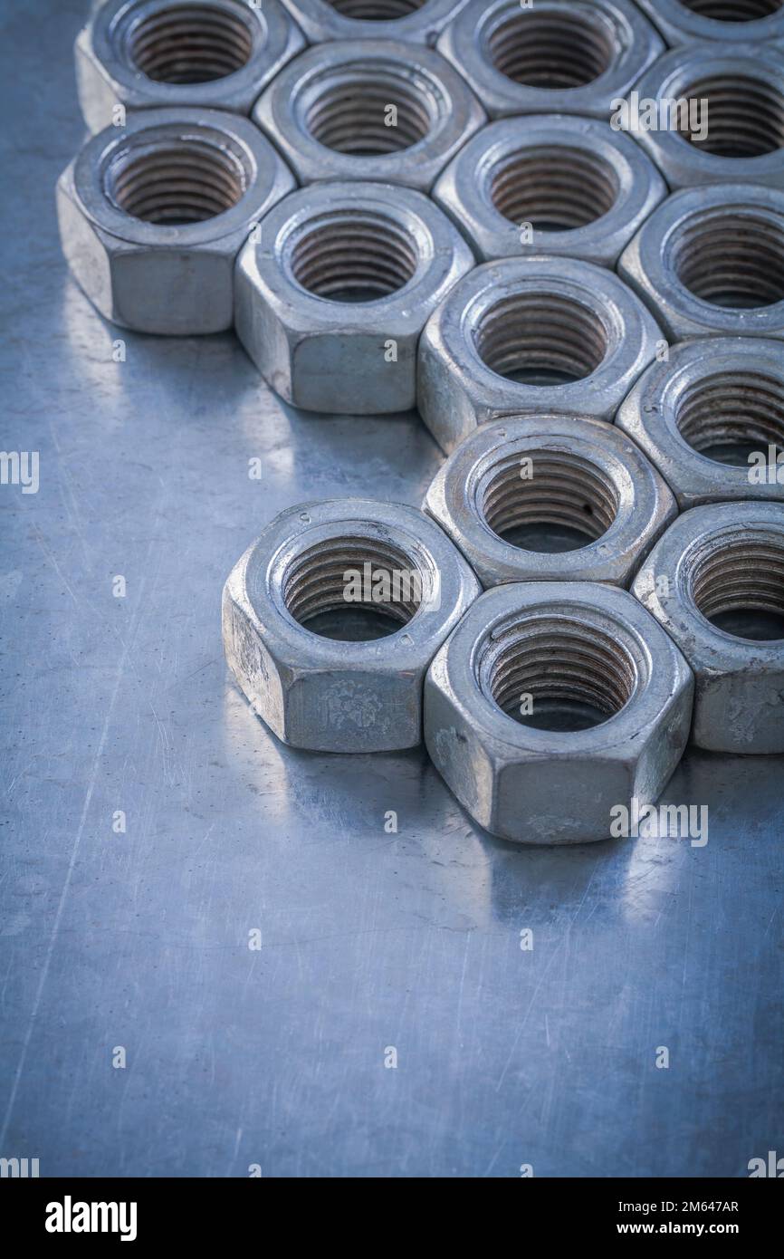 Stack of construction nuts on metallic background maintenance concept ...