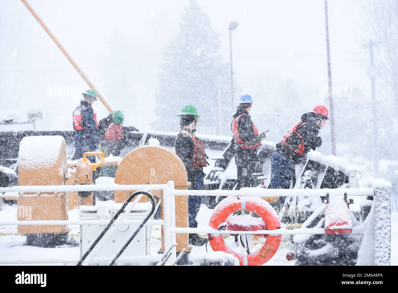 Crewmembers aboard CGC Spar handle lines on the focsle as the ship ...