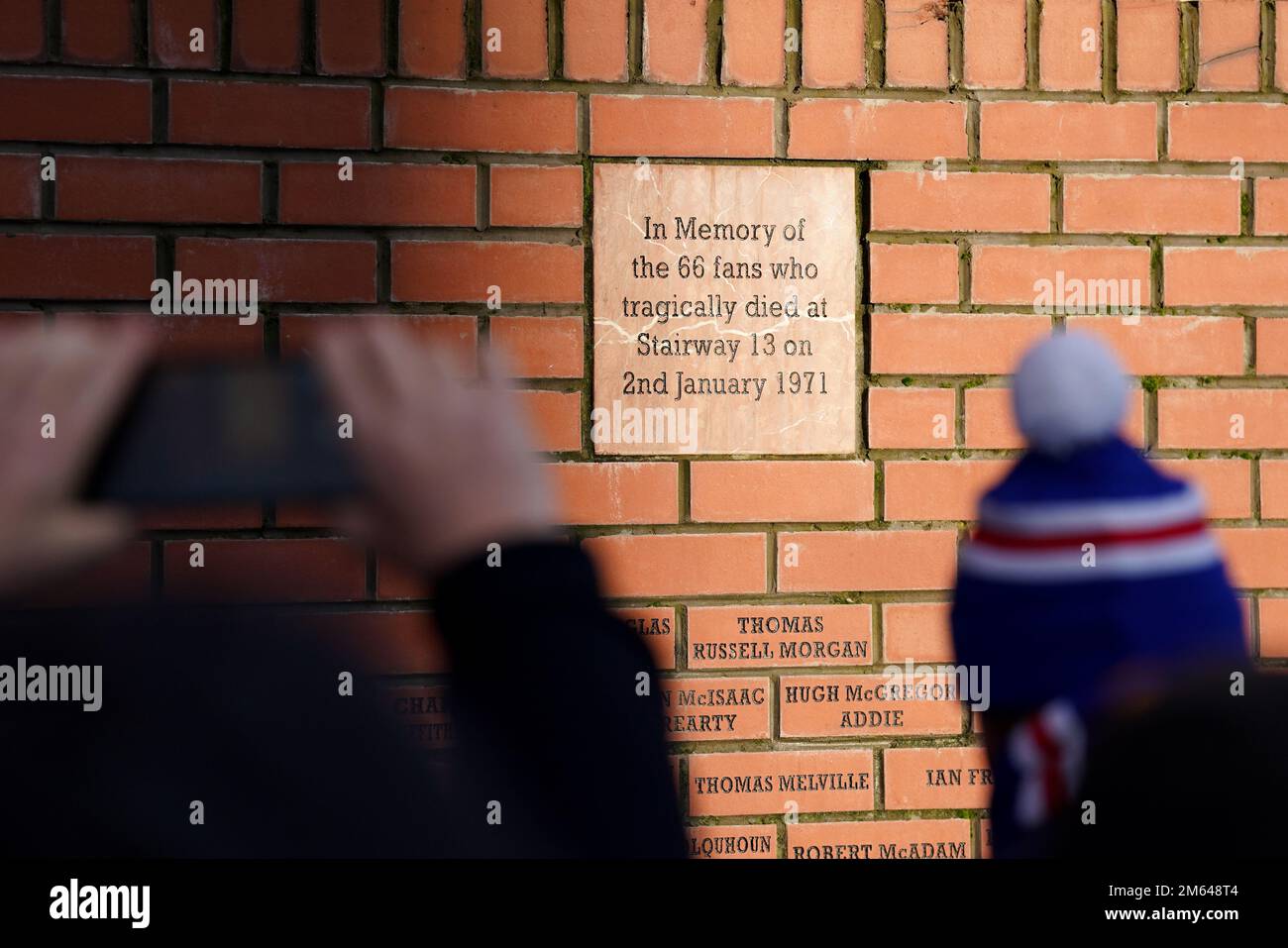 Fans take a photograph of a plaque in memory of the 1971 Ibrox disaster ...