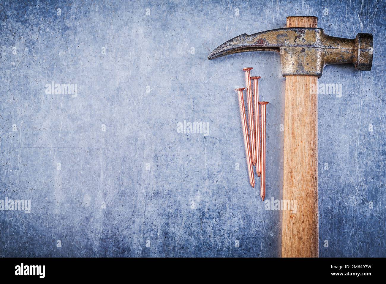 Vintage claw hammer brass construction nails on metallic background ...